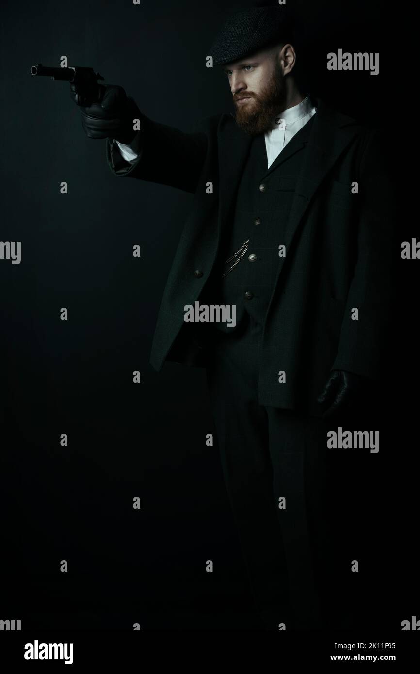 A working class Victorian man with red hair and beard against a black ...