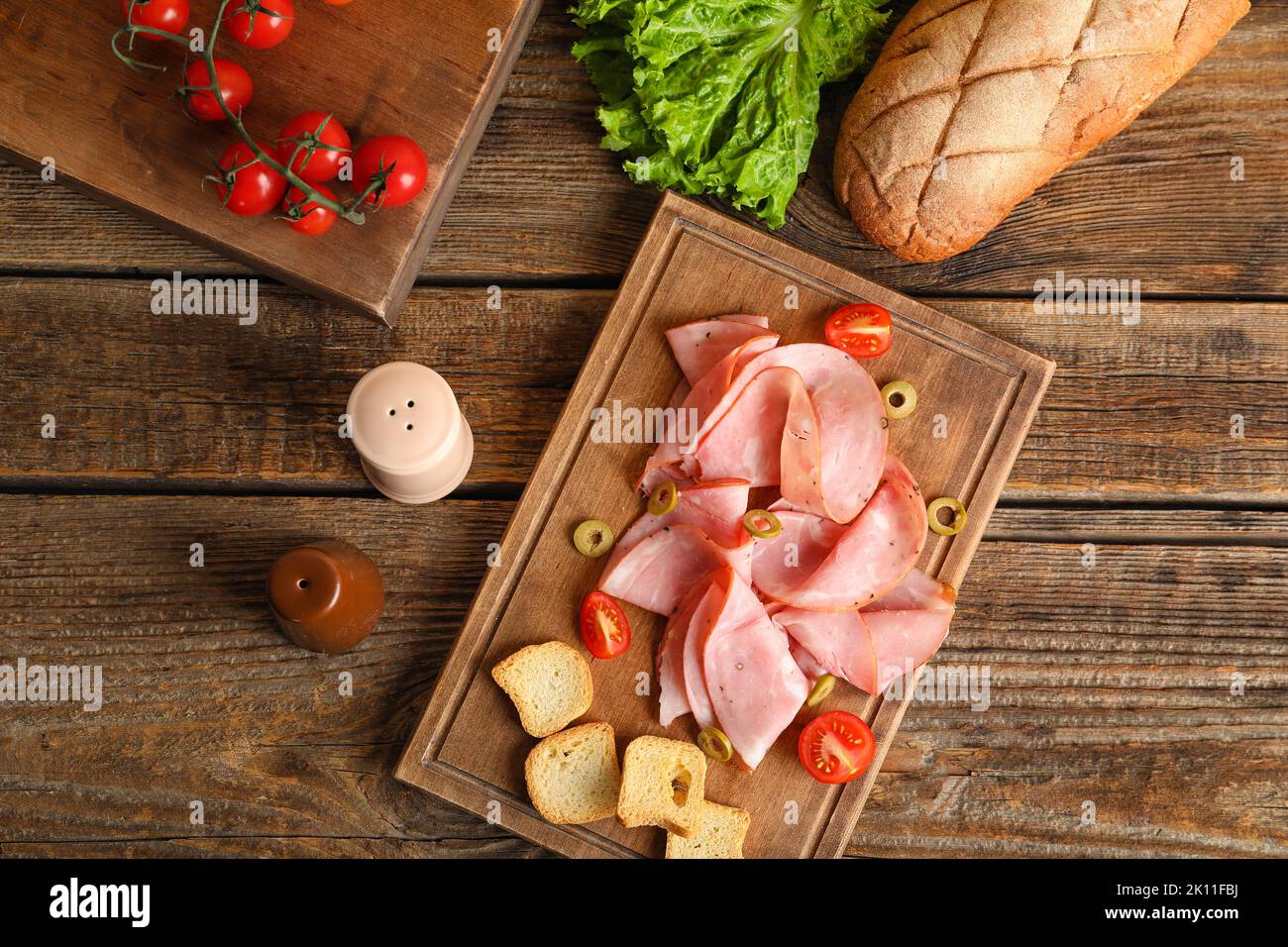 Board with tasty ham and crackers on wooden background Stock Photo - Alamy