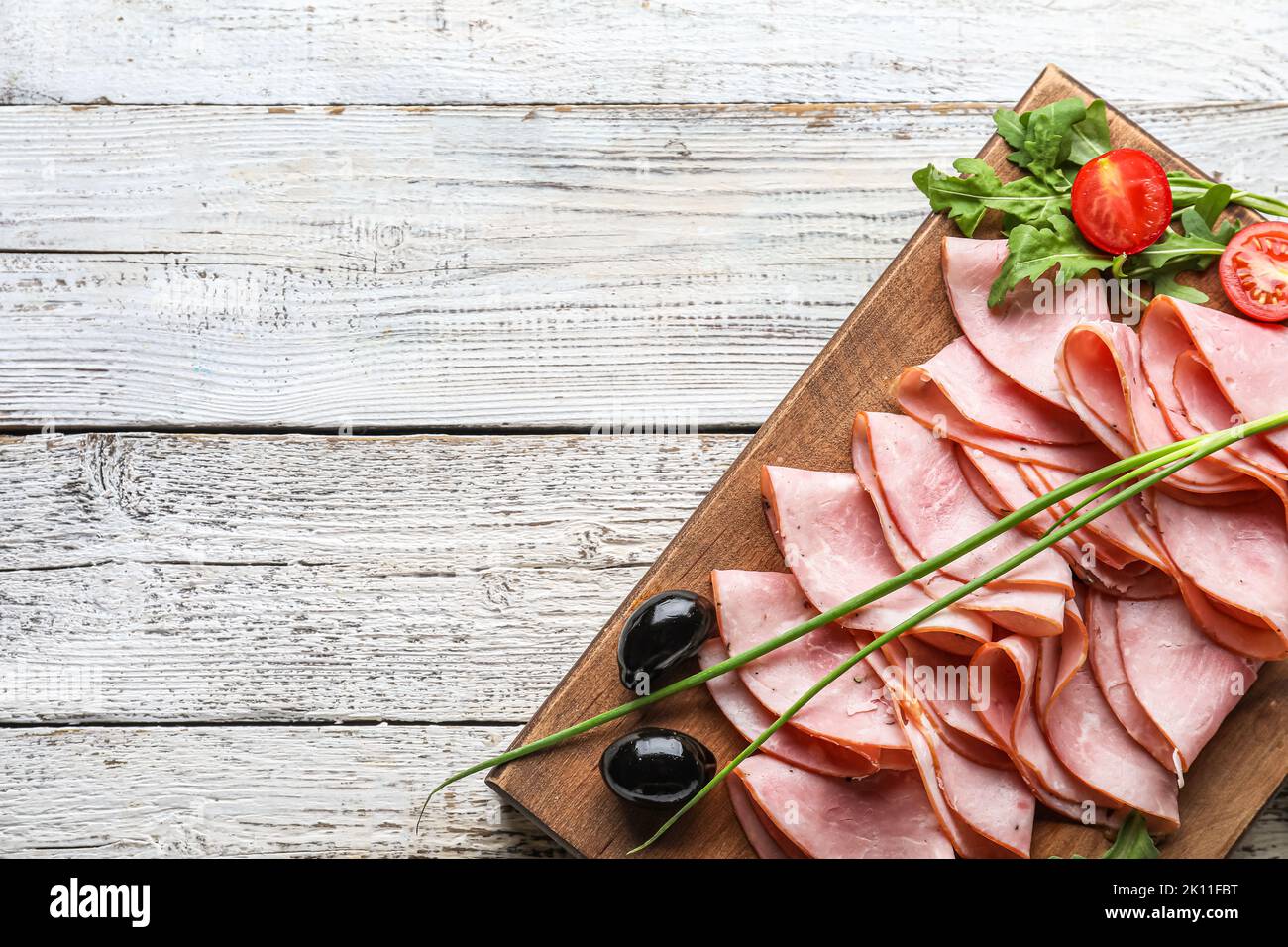 Board with slices of delicious ham on light wooden background Stock ...