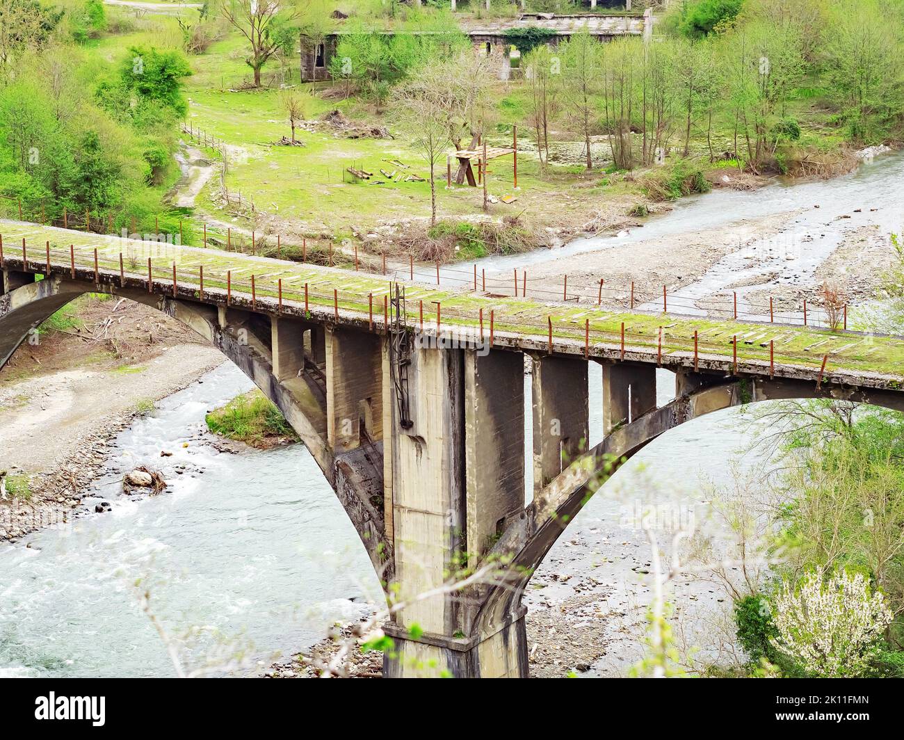 Abandoned old high overgrown bridge. Old high bridge across river ...