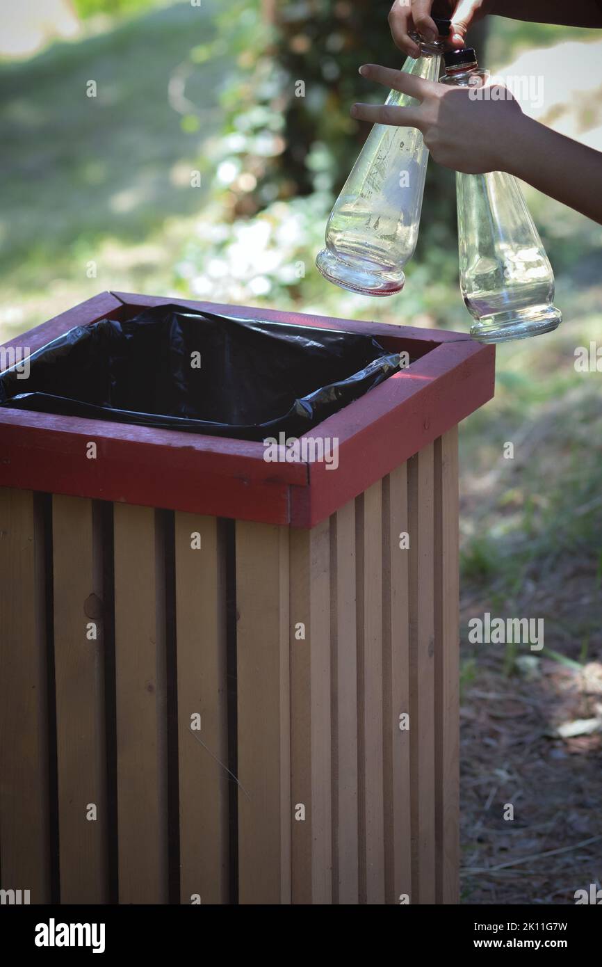 In the hands of two empty glass bottles with a bucket. Ejection of ...