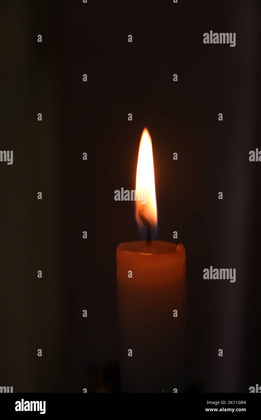 Defocus close up single candle light and flame on black background ...