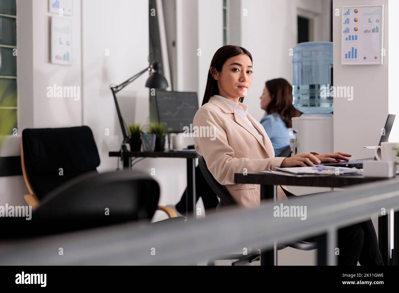 Confident company employee working on laptop in coworking space ...