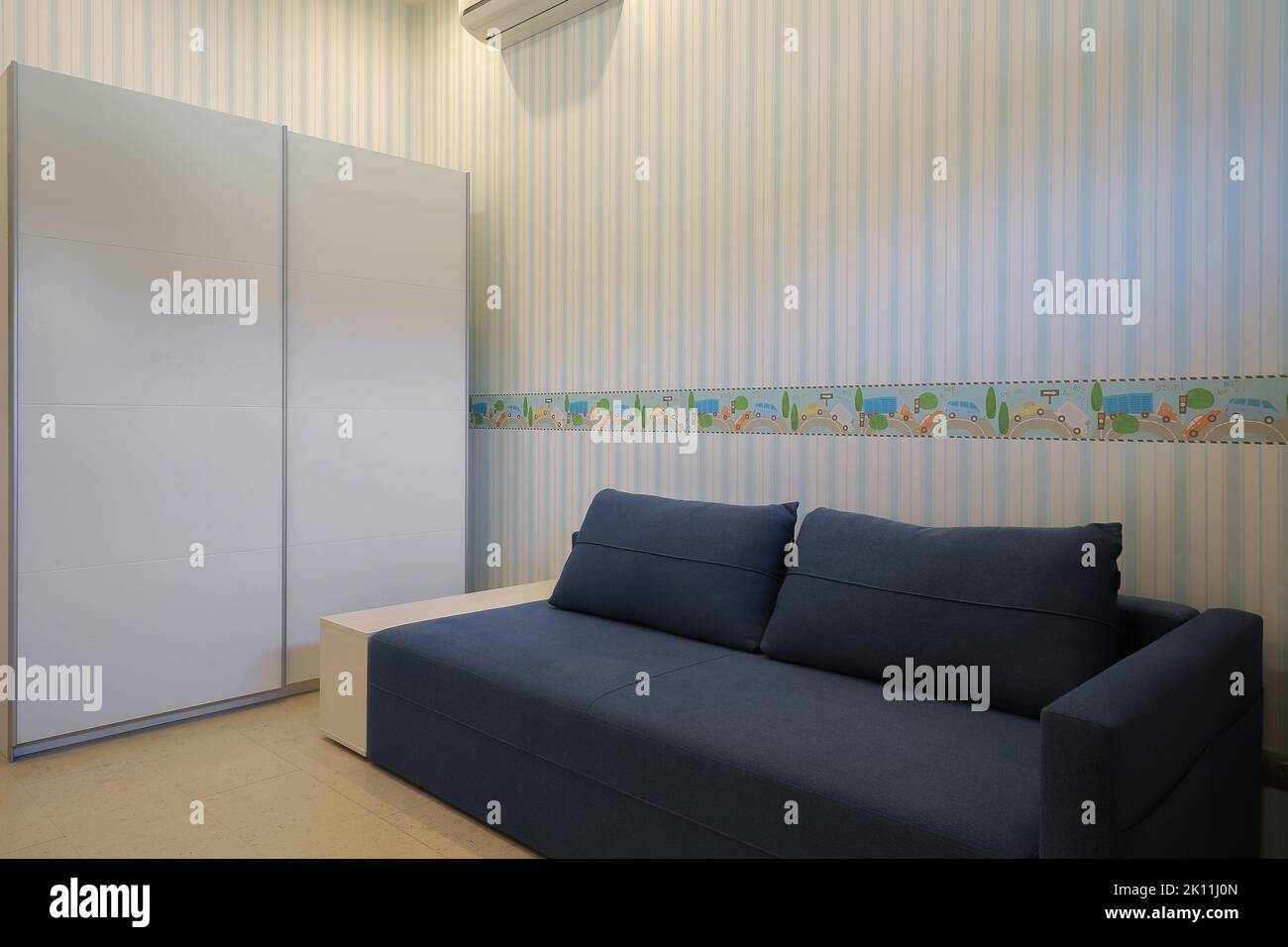 Sofa and white sliding wardrobe in the children room Stock Photo - Alamy