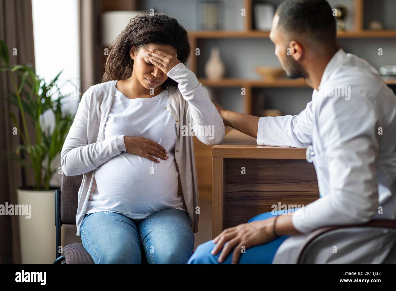 Pregnant black woman feeling bad, visiting doctor at clinic Stock Photo ...