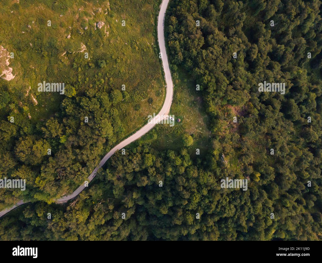 Top down aerial drone view of the road in mountain range trough the ...