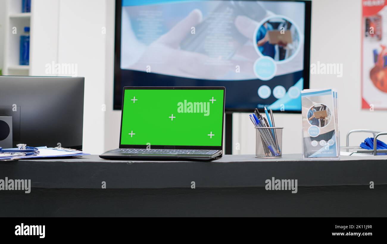 Greenscreen on laptop at hospital reception desk in medical waiting ...