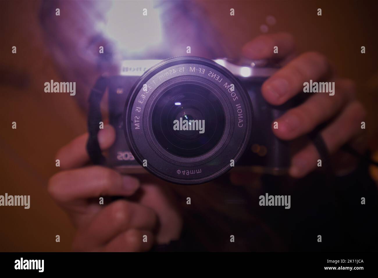 Person taking a photograph up close with ambient lighting Stock Photo ...