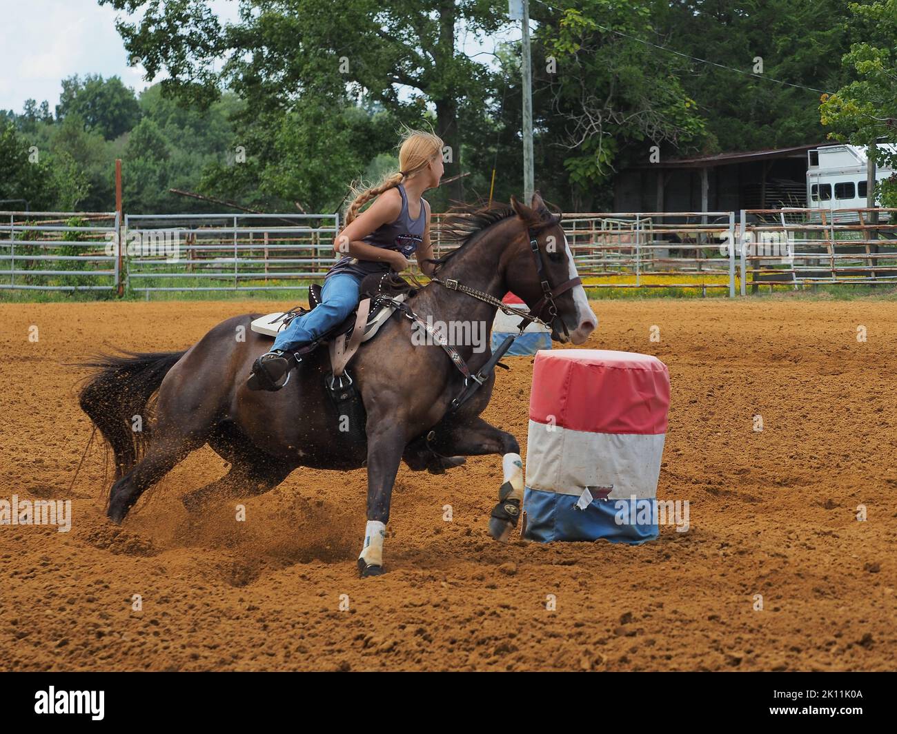 Young female Barrel racing riding a brown quarter horse Stock Photo - Alamy