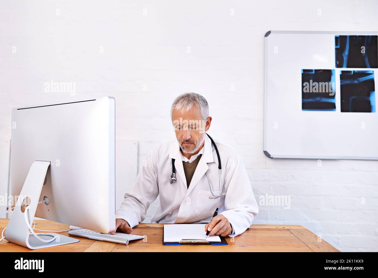 Doctor writing in patient chart hi-res stock photography and images - Alamy