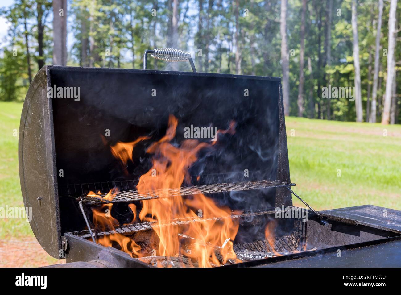 In preparation for grilling with firewood, prepare a BBQ with a blazing ...