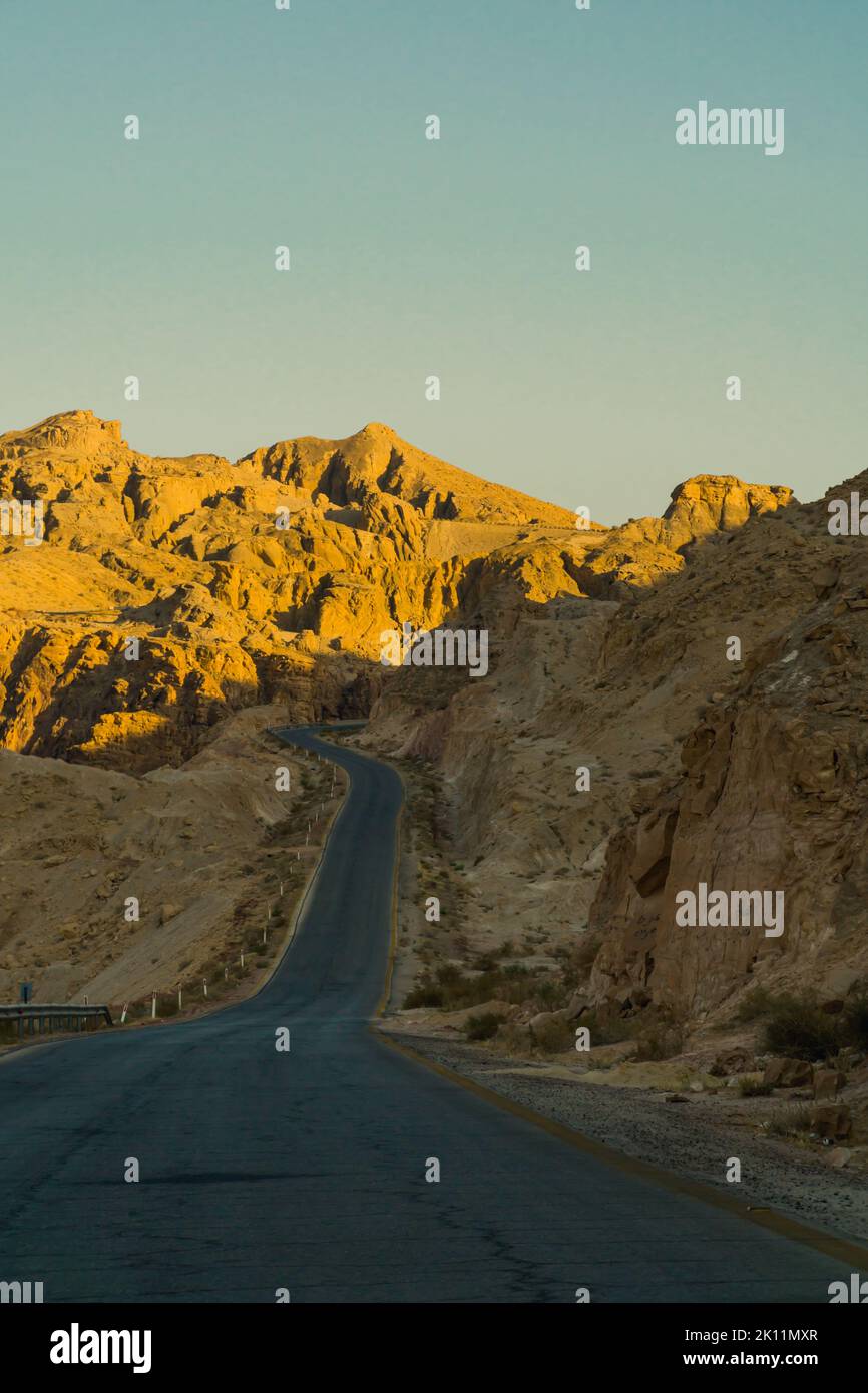 beautiful road running through the wadi rum desert with rocky mountains ...