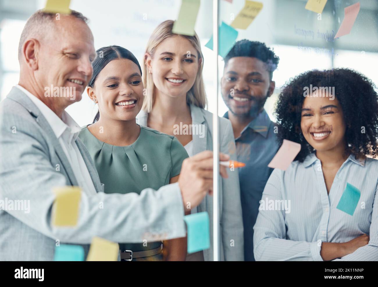 Team, strategy and business people writing on sticky notes in a meeting ...