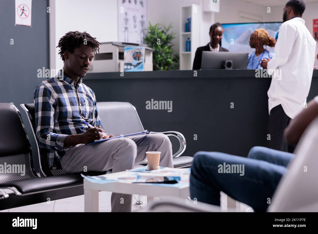 African american patient filling in report papers before checkup visit ...
