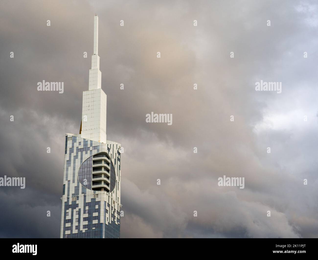Tall building with a spire against the backdrop of clouds. The storm is ...