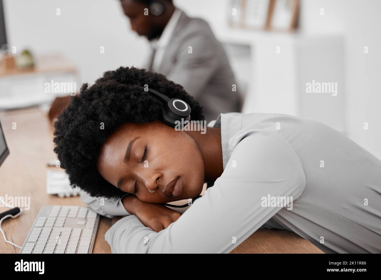 Call center, burnout and sleep of a woman employee resting on a desk at ...