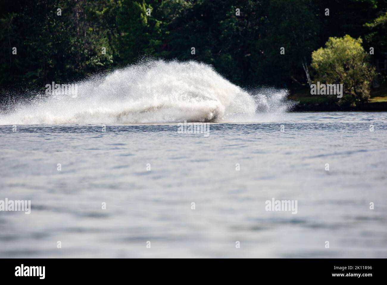 Wave and splash of water is covering the entire jet ski that is making ...