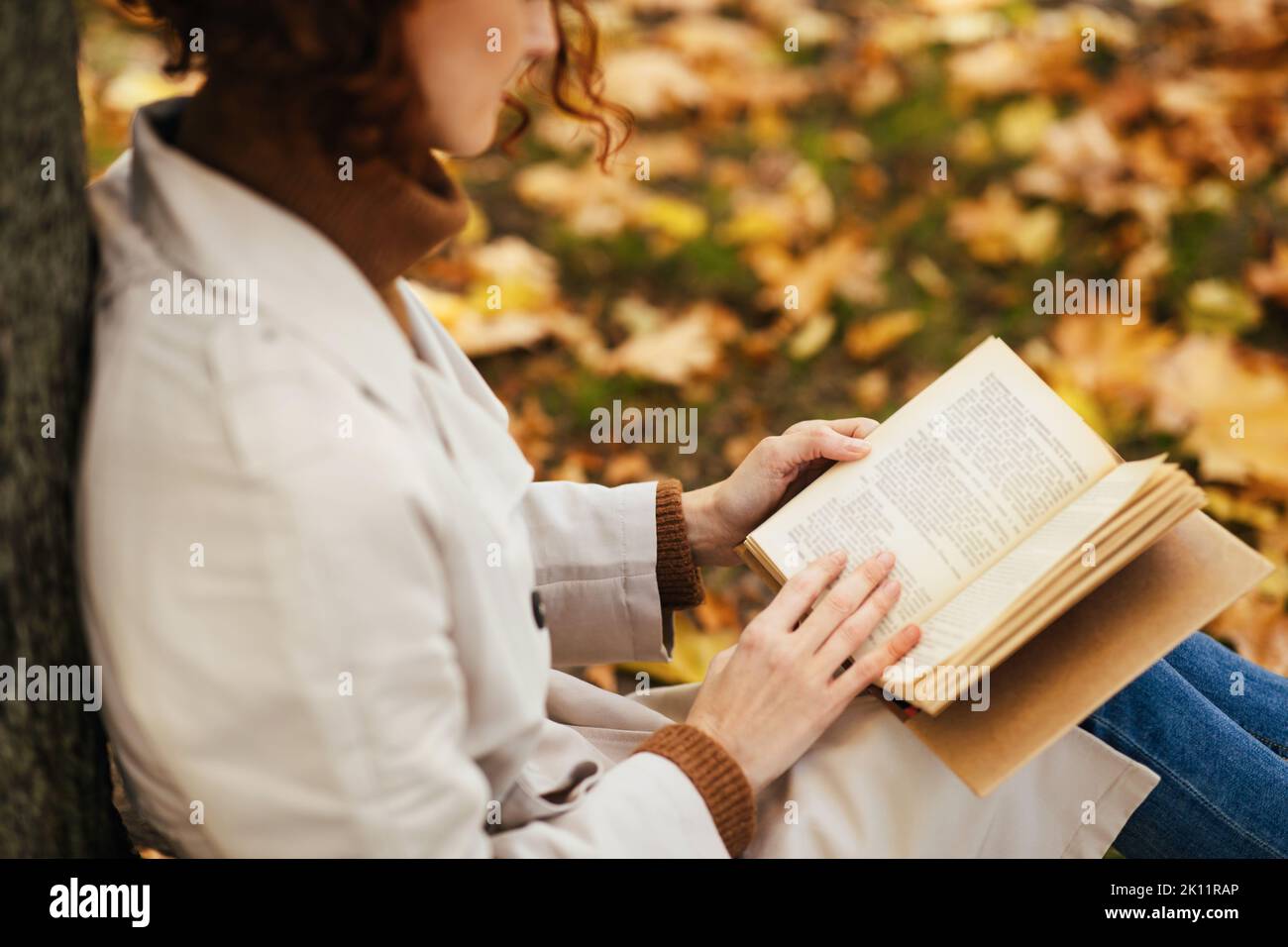 Serious concentrated caucasian millennial red-haired woman in raincoat ...