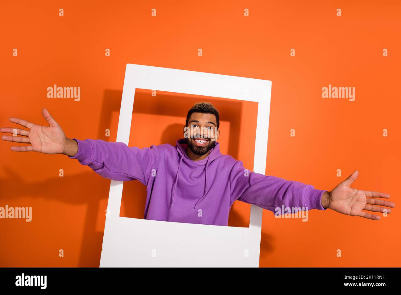Photo of cheerful nice young man raise opened hands through paper album ...