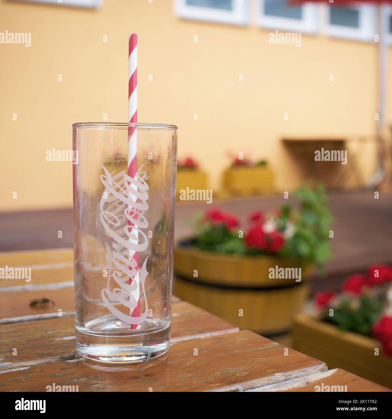 empty Coca-Cola glass with straw on table in restaurant Stock Photo - Alamy