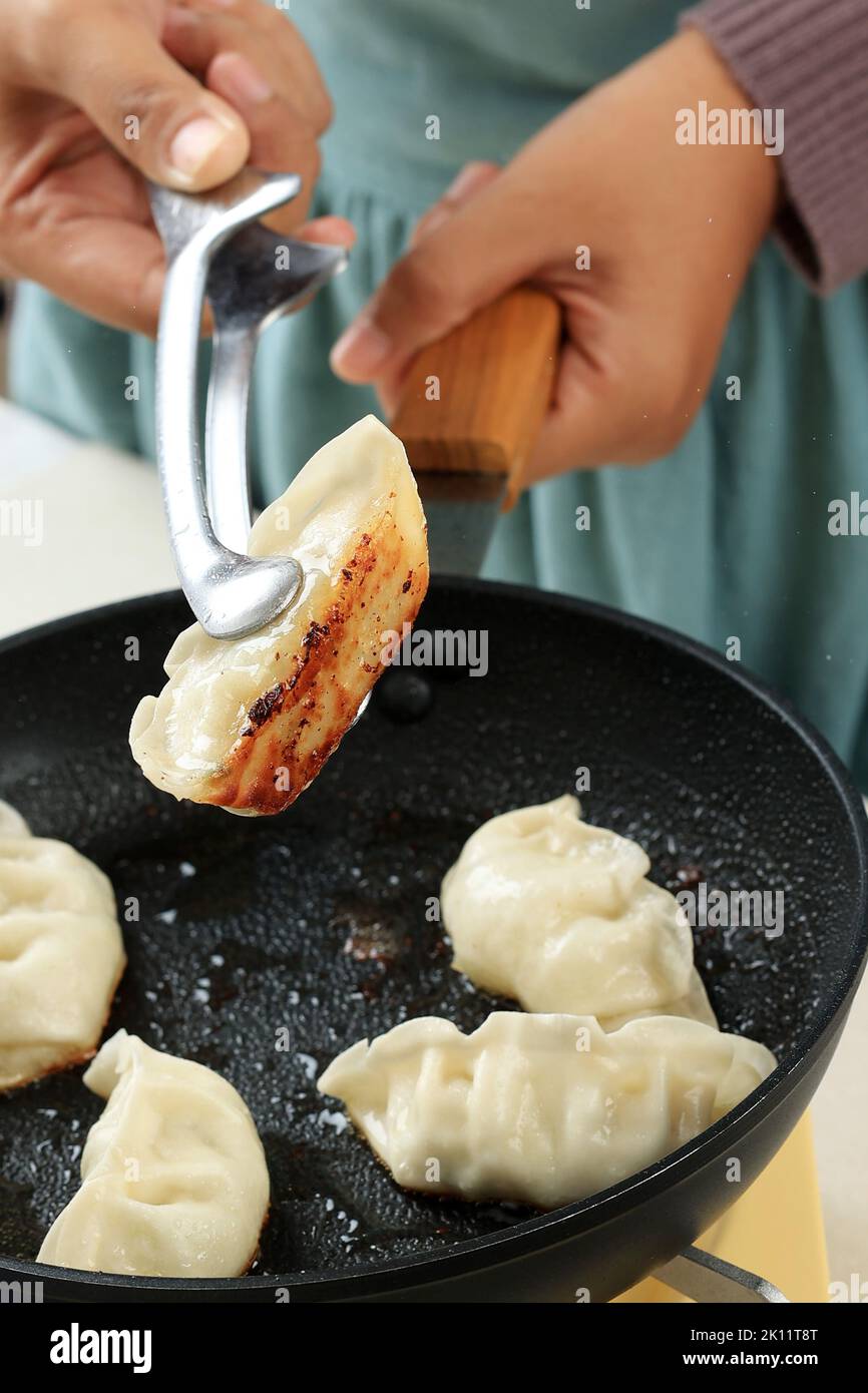 Hand holding cooking tongs hi-res stock photography and images - Alamy