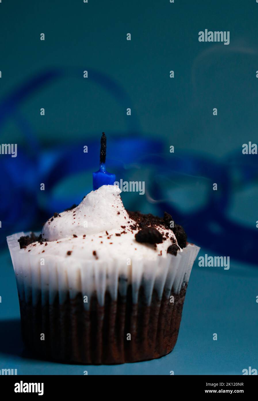 chocolate cupcake with white buttercream and blue candle, dark ...
