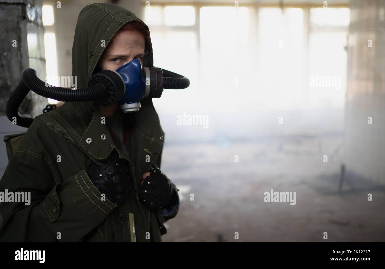 Young pandemic survivalist woman in gas mask looking in front of her on ...