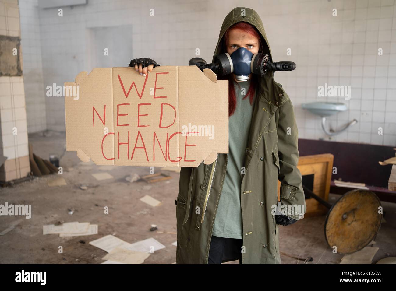 A poster with the words WE NEED A CHANGE in the hands of a young woman ...