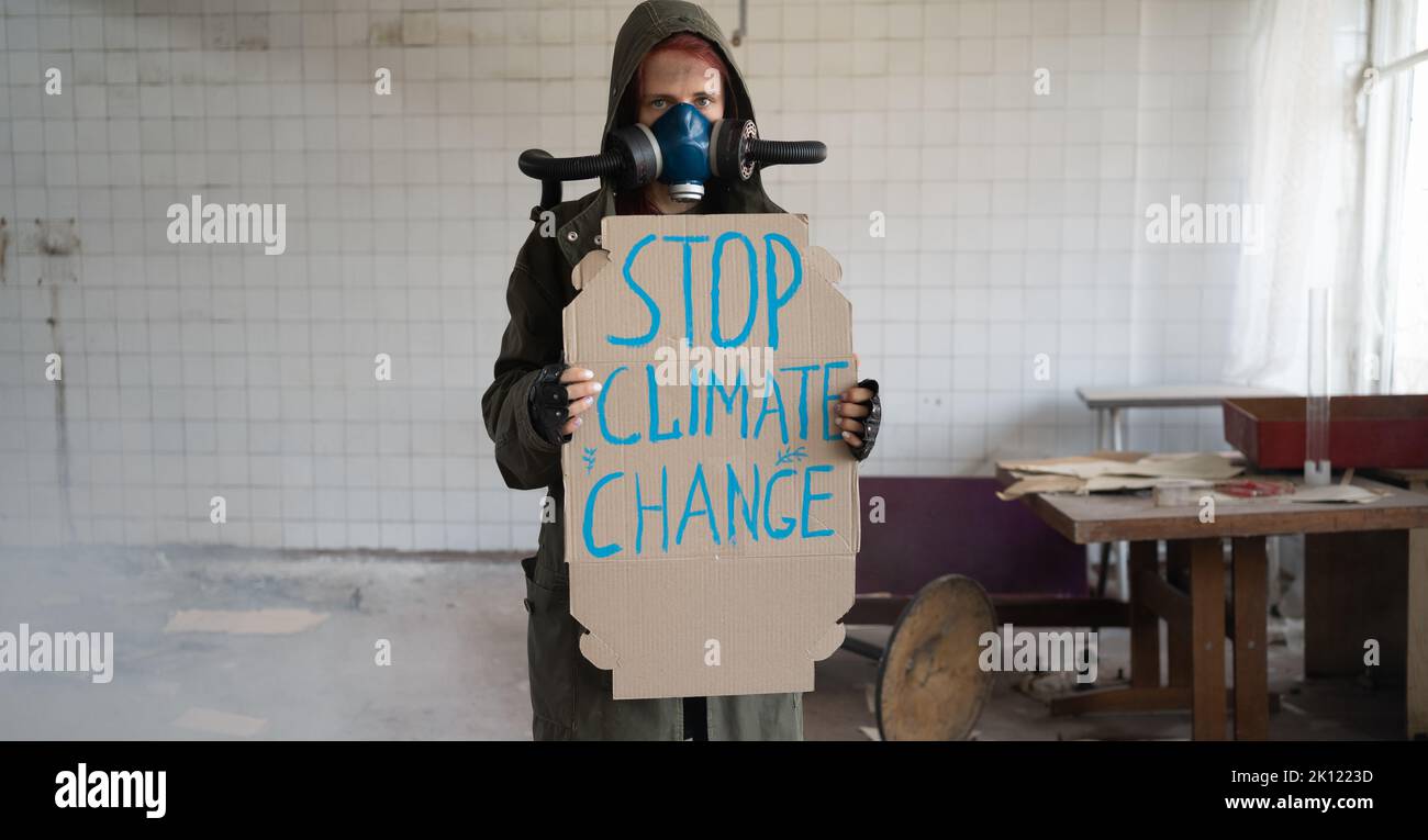 Female stalker in gas mask with banner says stop climate change ...