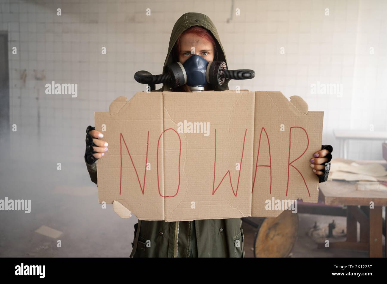 No war concept. Angry woman in protective uniform and gas mask after ...
