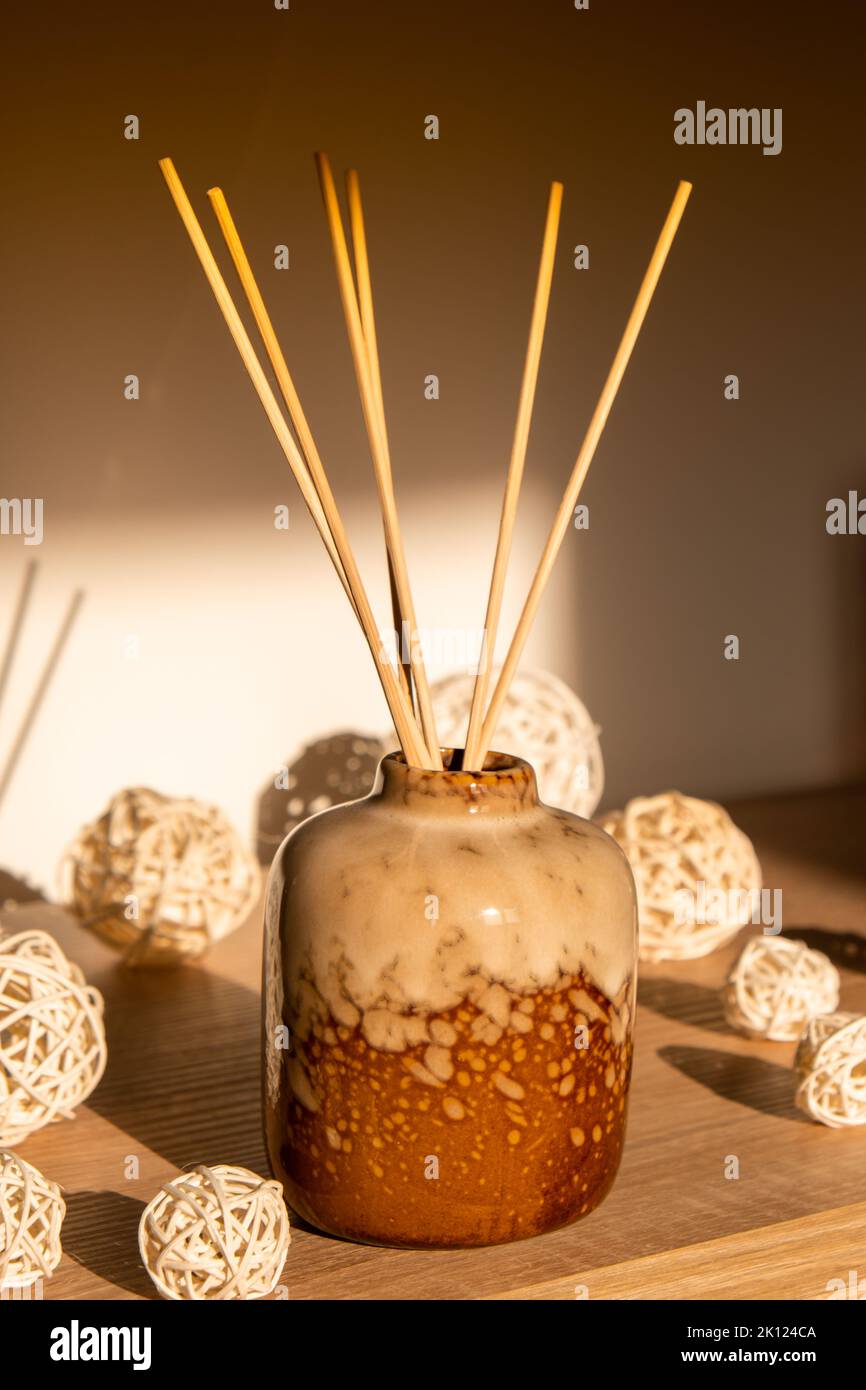 Cozy home decorations aroma reed diffuser in the living room. Home comfort concept. Bottle ...