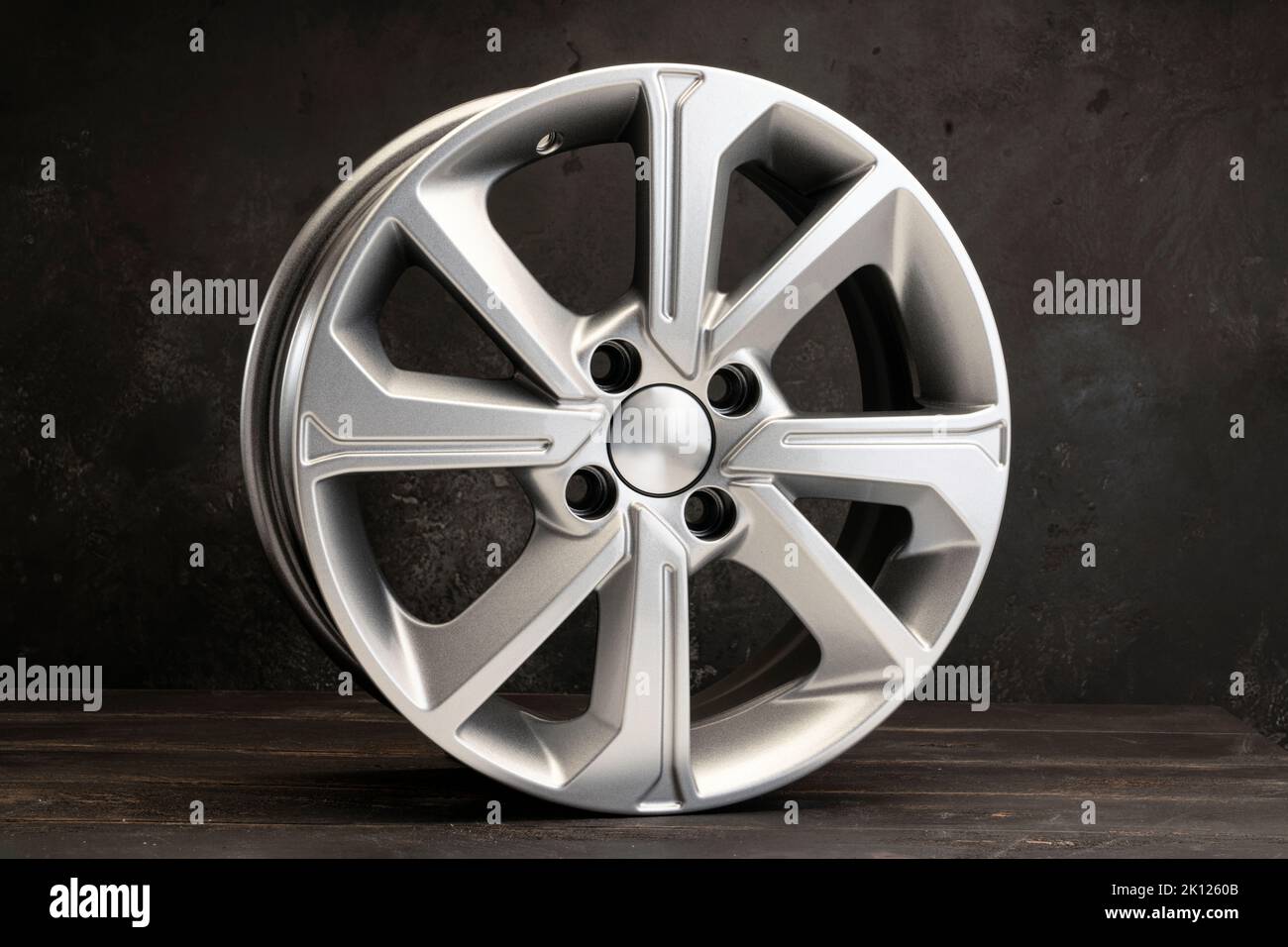 new grey alloy wheels on a dark textured black background. a wheel for ...