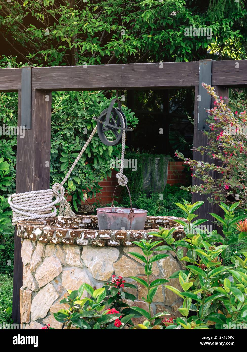 Beautiful artesian well made by stones and wheel pulley with metal ...