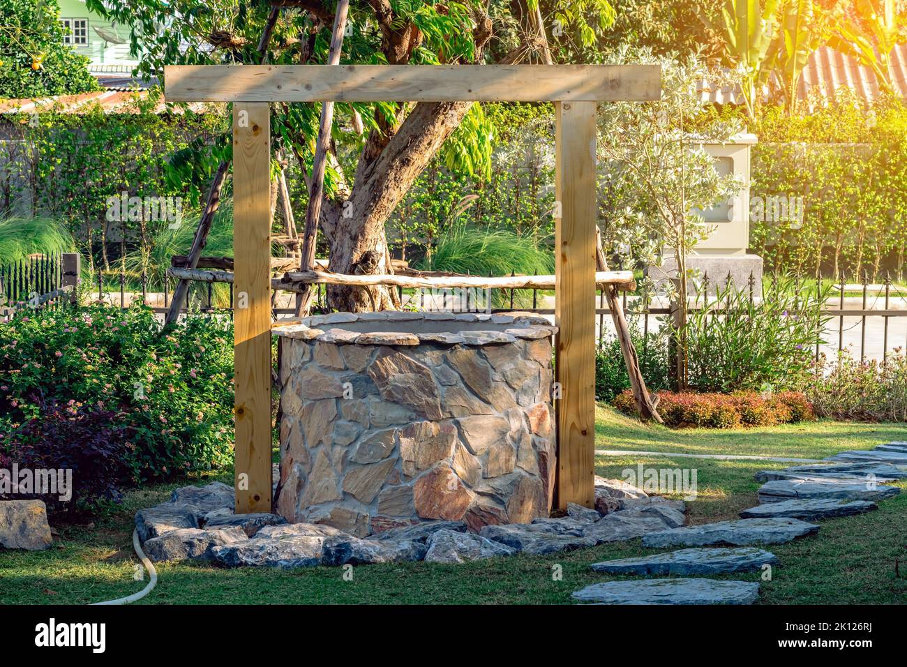 Beautiful artesian well made by stones and wood in peaceful garden ...