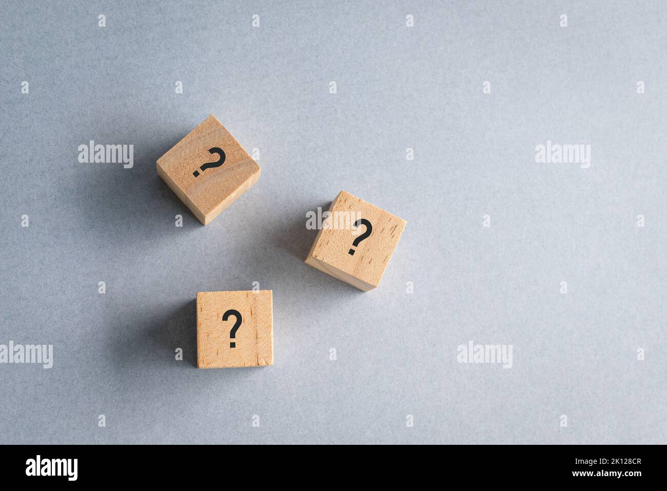 Three wooden cube block shape with sign question mark on them. Top view ...