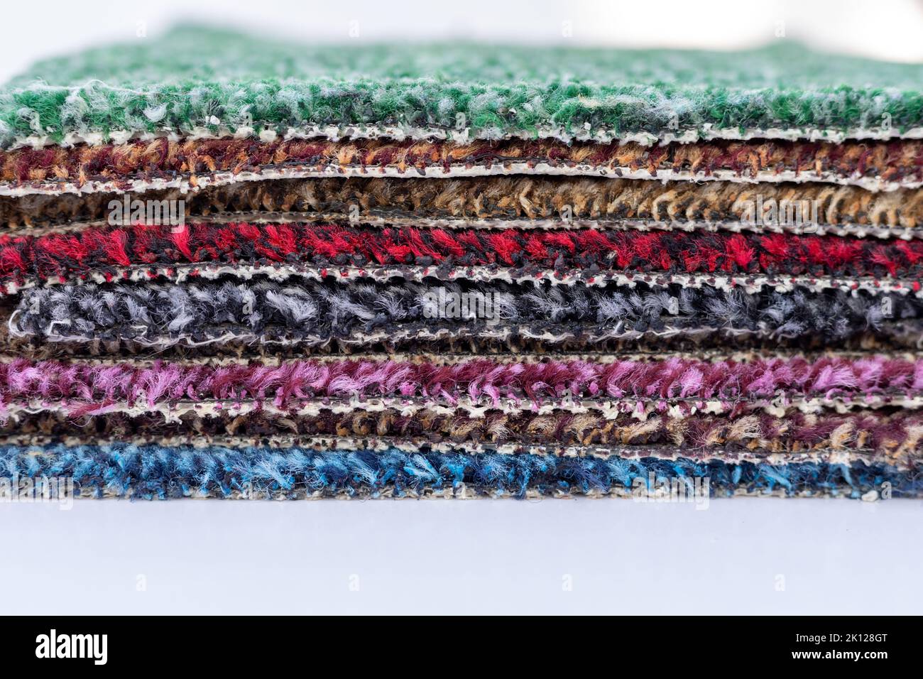 A set of colorful carpet sample stack over each other in the store with ...