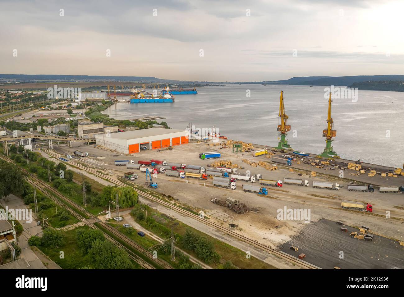 Trucks and port cranes ready to load from cargo ships. Horizontal view ...
