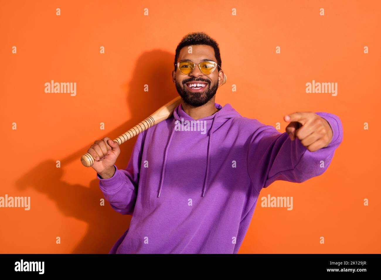 Photo of positive carefree guy hold baseball bat point finger camera ...