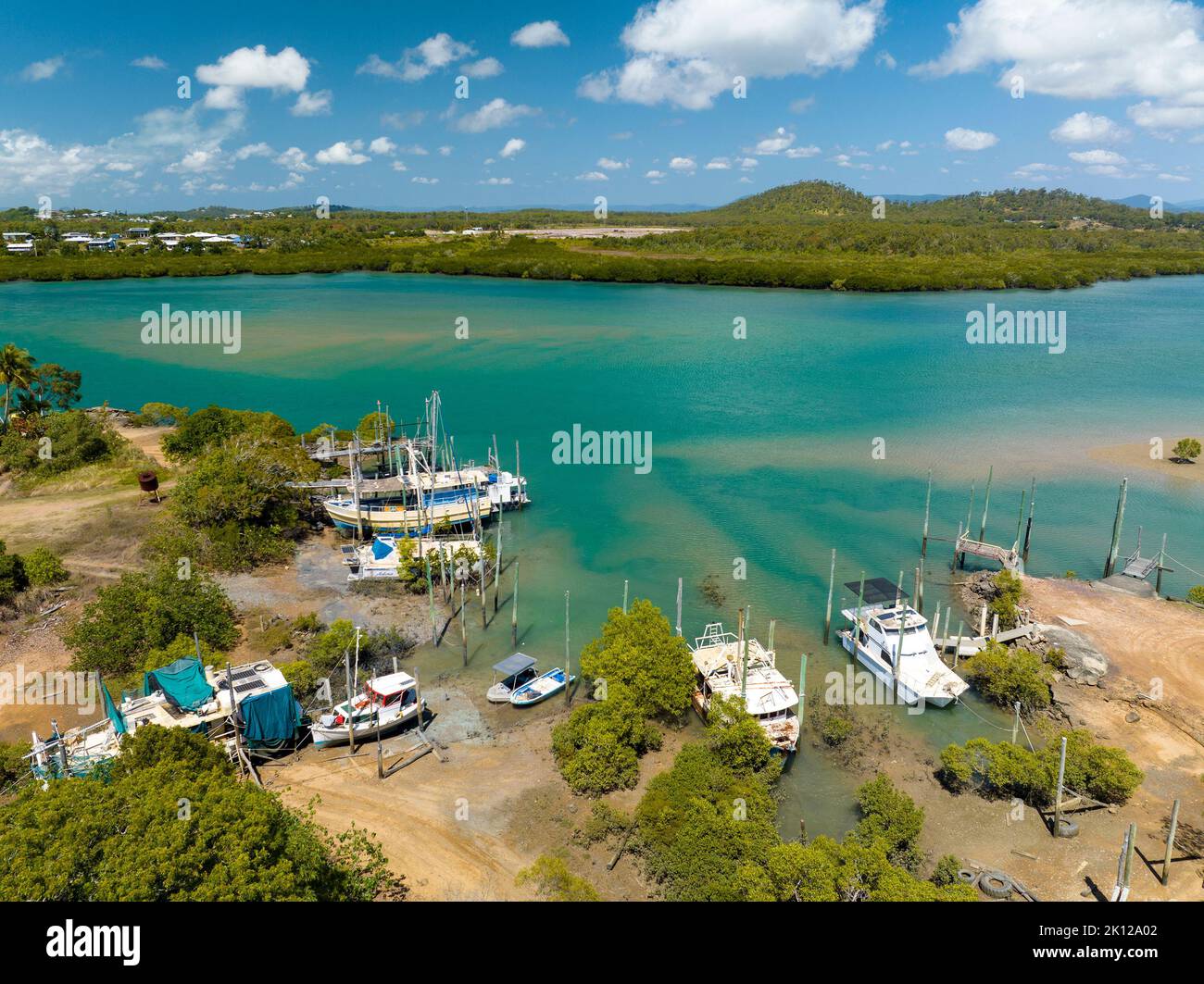 Boats moored on the banks of Grasstree Beach on the incoming tide ...