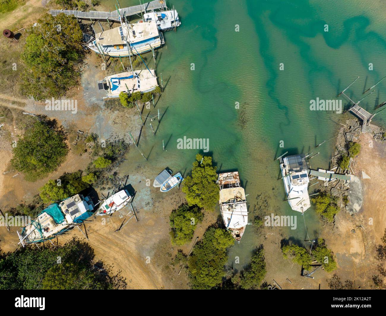 Boats moored on the banks of Grasstree Beach on the incoming tide ...