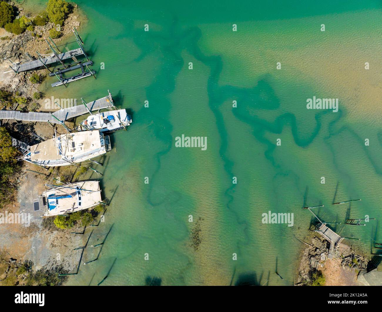 Boats moored on the banks of Grasstree Beach on the incoming tide ...