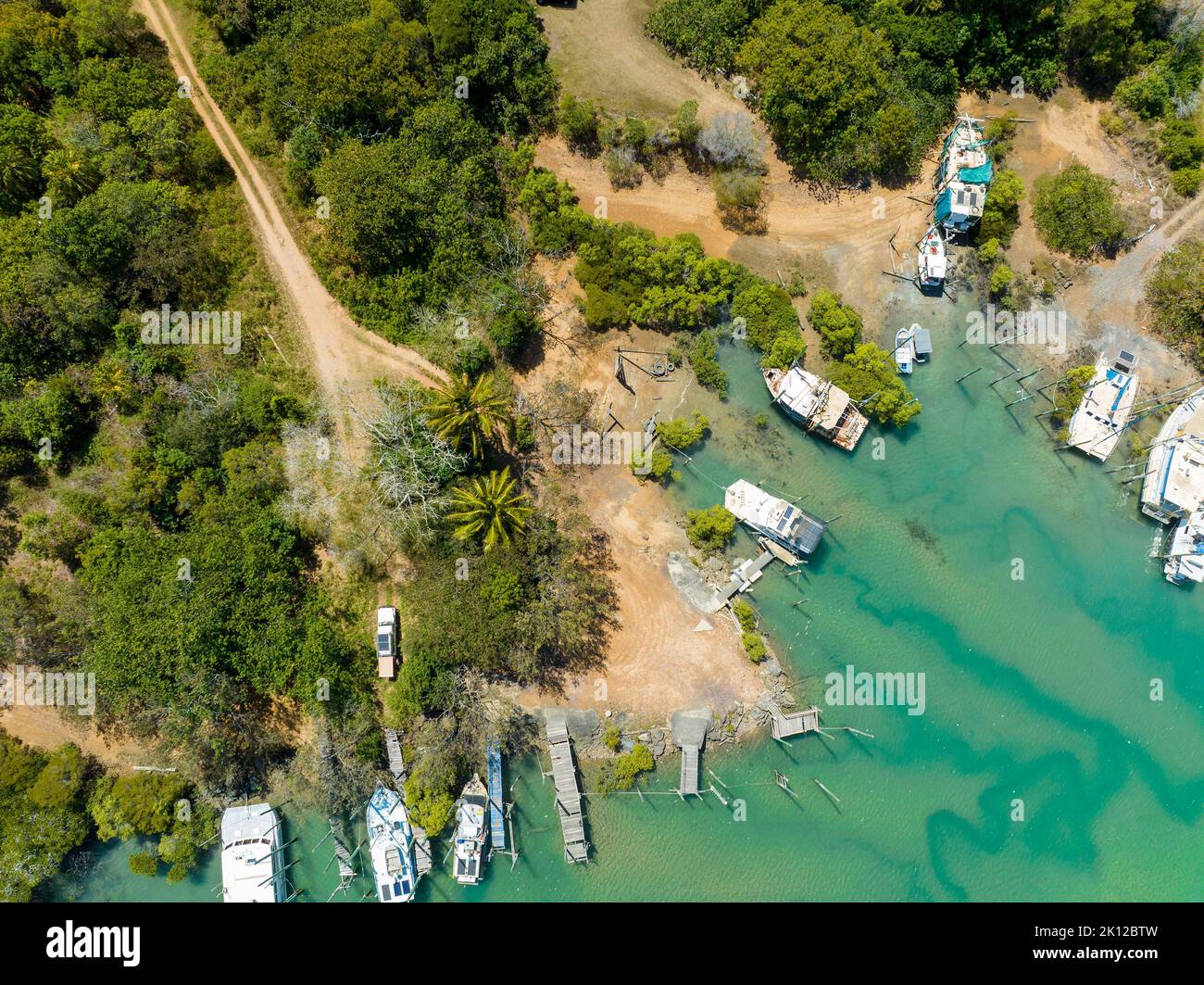 Boats moored on the banks of Grasstree Beach on the incoming tide ...