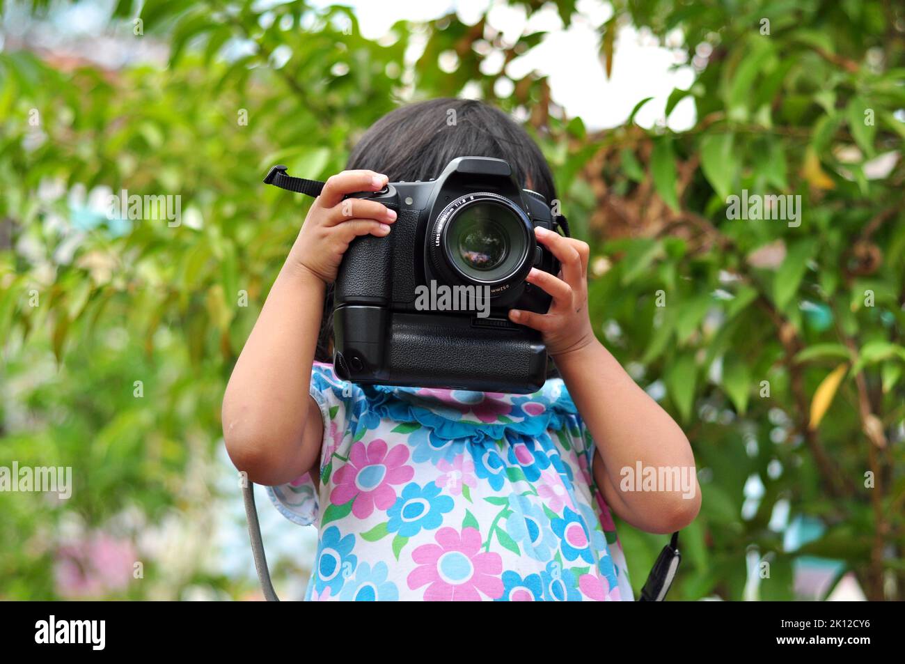 West Java, Indonesia - August 20, 2012 : A little girl in a floral ...