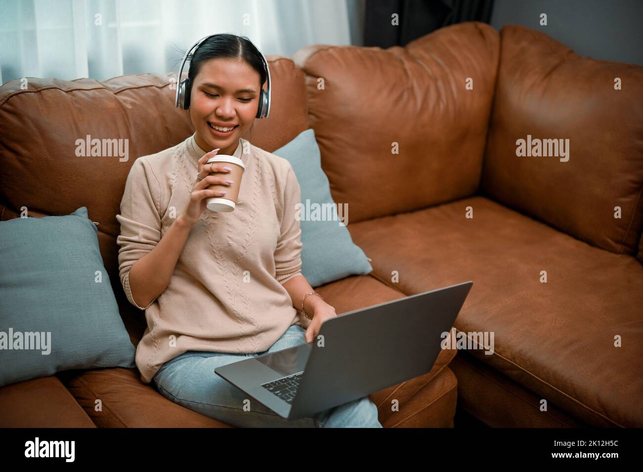 Relaxed and happy young Asian woman enjoy listening to music through ...
