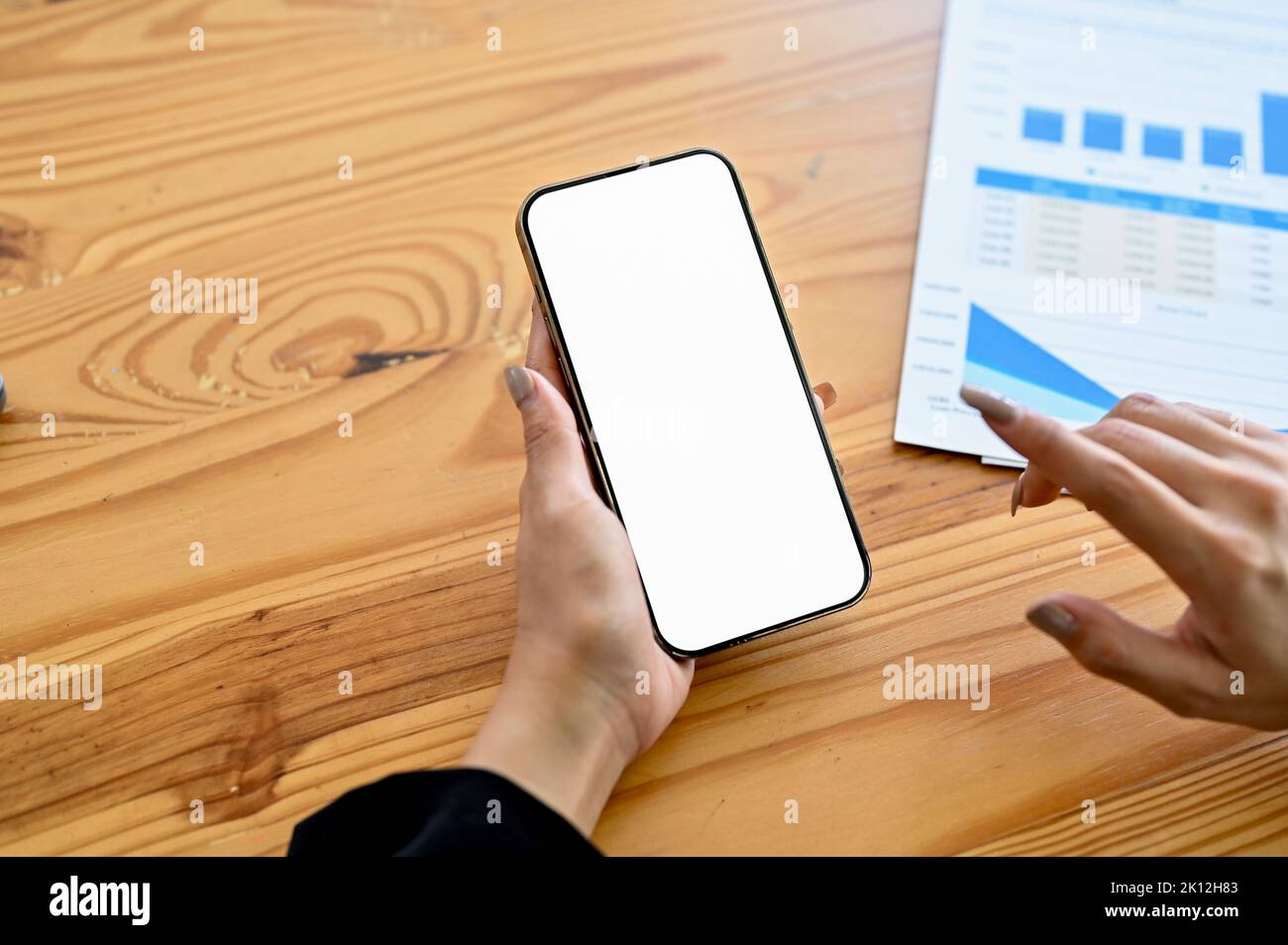 A businesswoman using her smartphone at her office desk, phone white ...