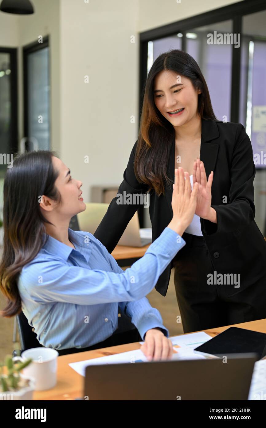 Portrait, Attractive and cheerful young Asian businesswoman giving high ...