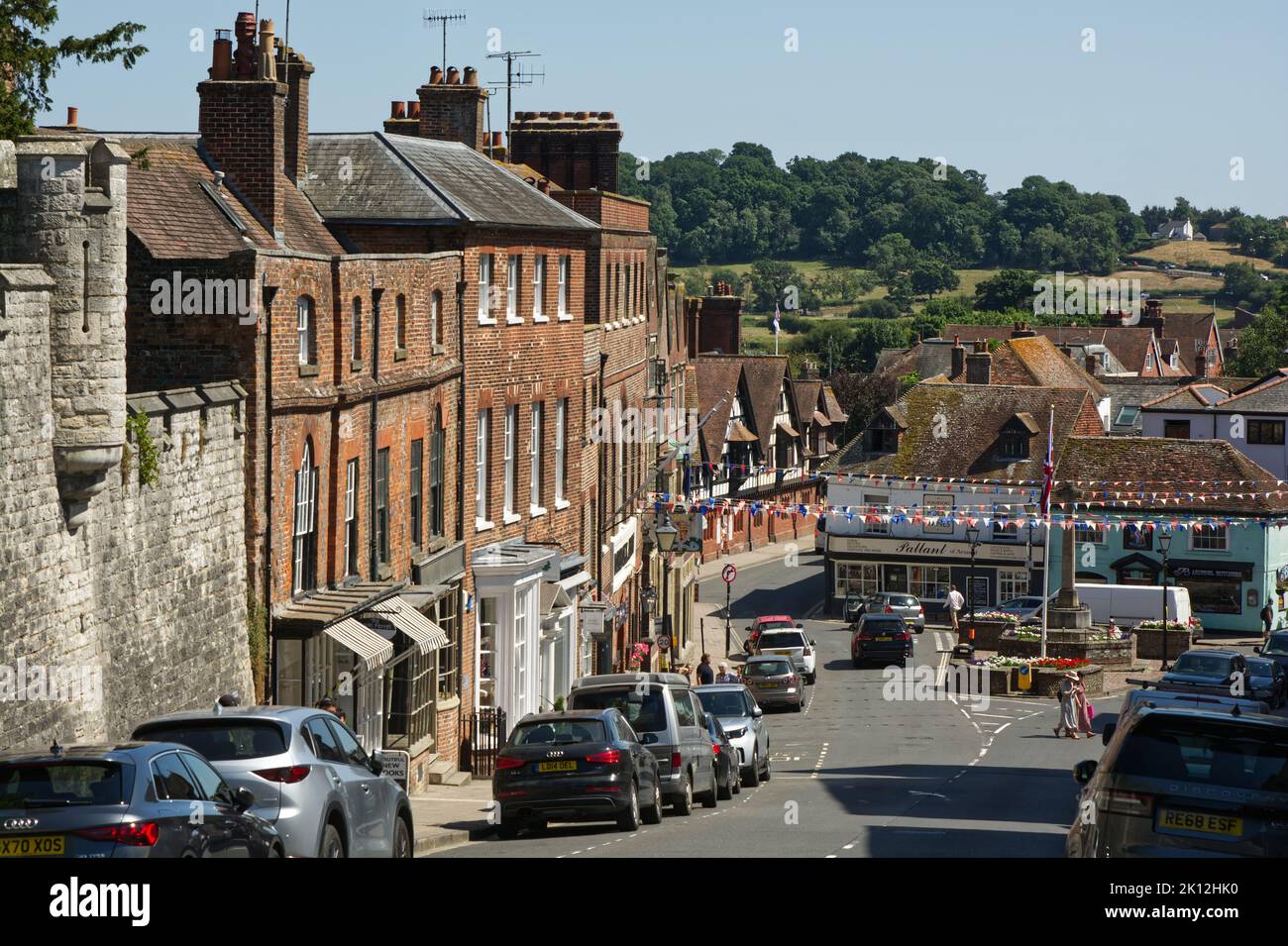 View down the High Street in Arundel, West Sussex, England. Castle wall ...