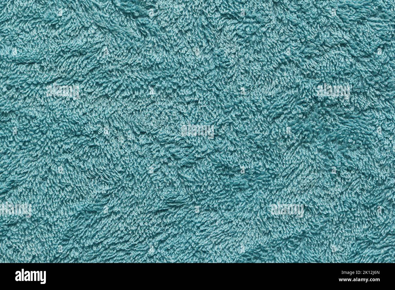 An extreme close-up of a light green fluffy, shaggy, bathroom towel ...