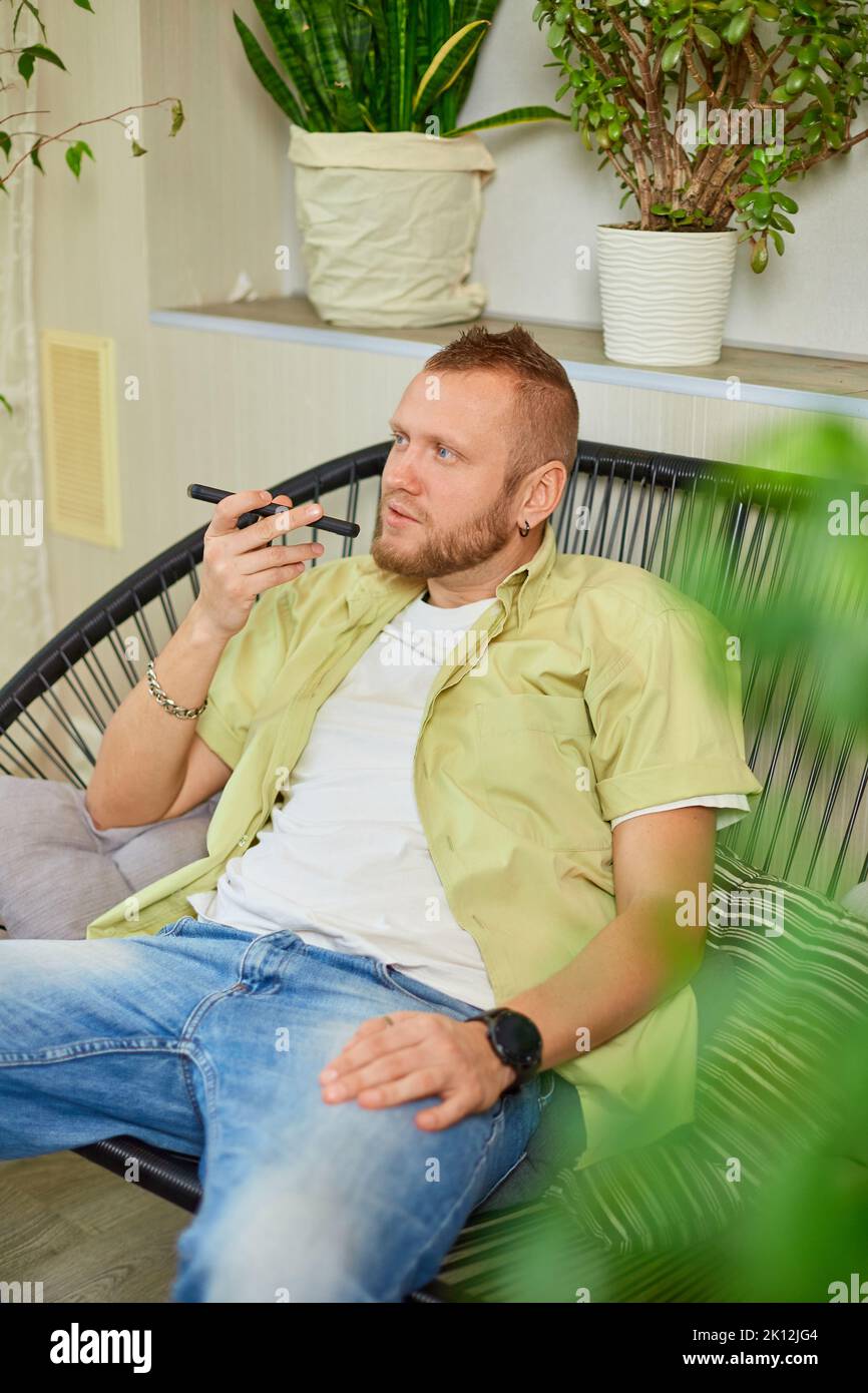 Happy smiling man holding mobile phone speaking talking with friends or ...