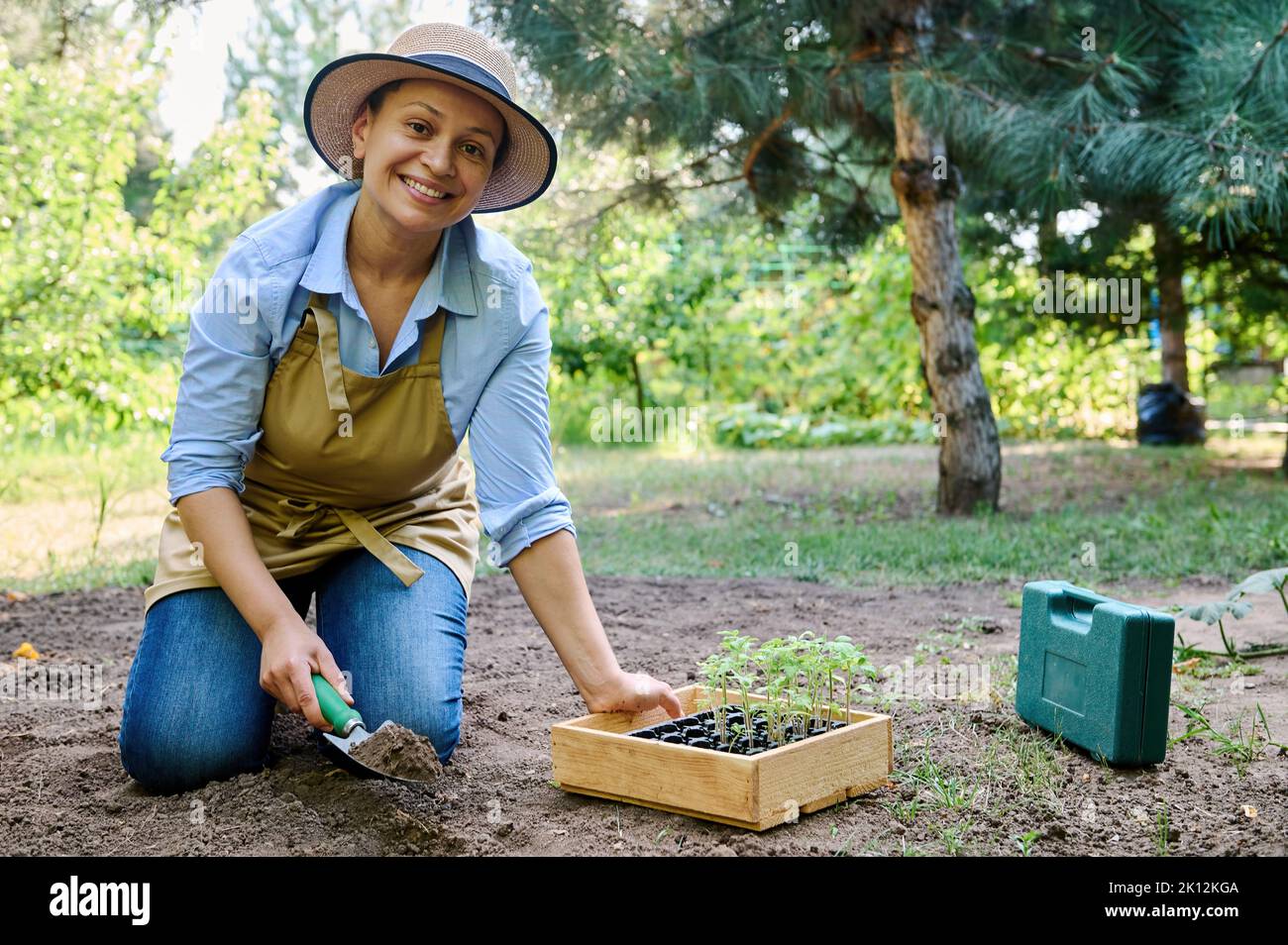 Beautiful middle-aged woman, farmer amateur working in the garden ...